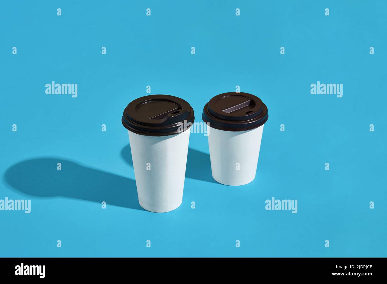 Flat lay design of 2 hot coffee cups on blue background with cop Stock ...