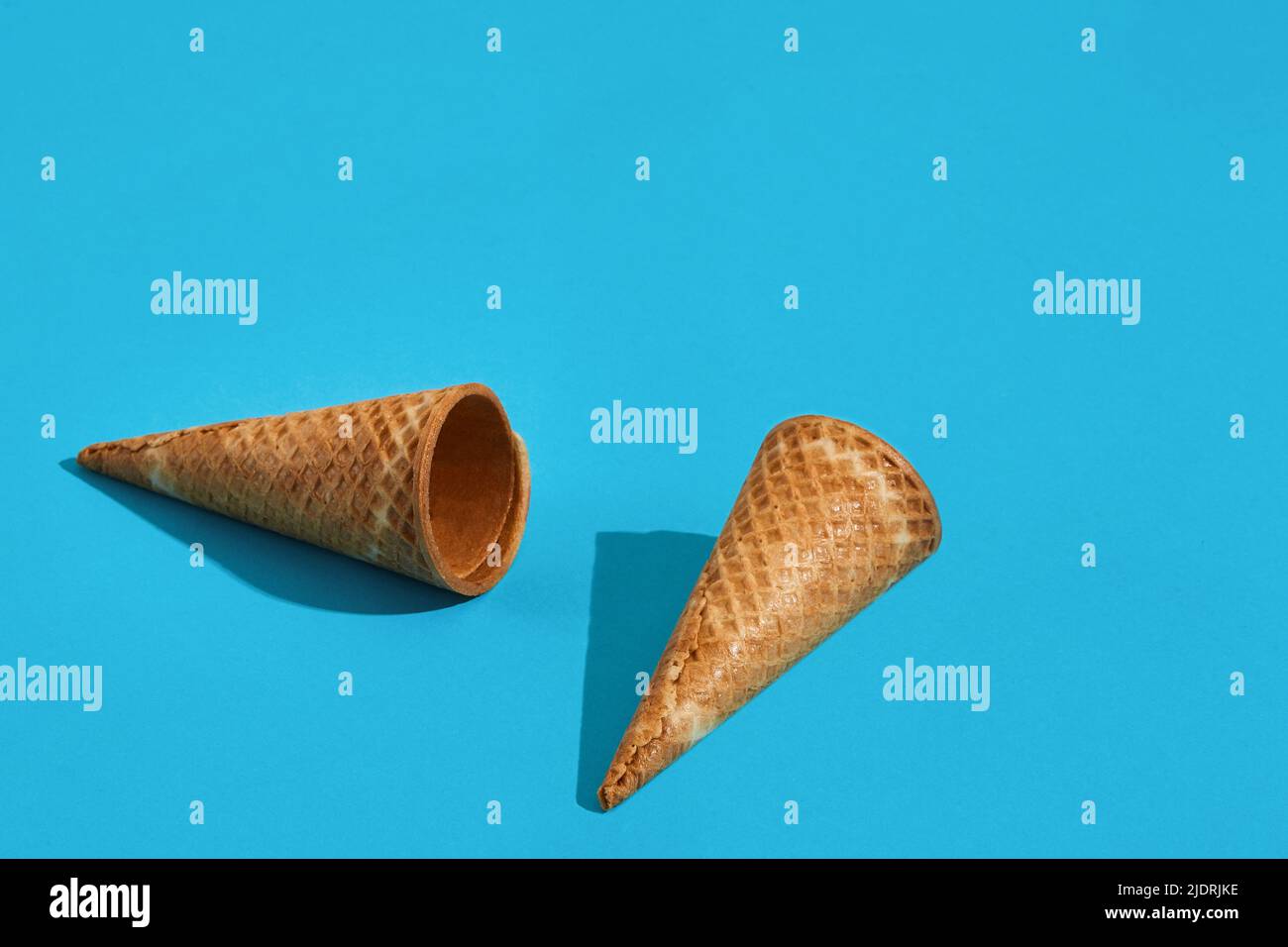 Two waffle ice cream cones with shadow on a blue background Stock Photo ...