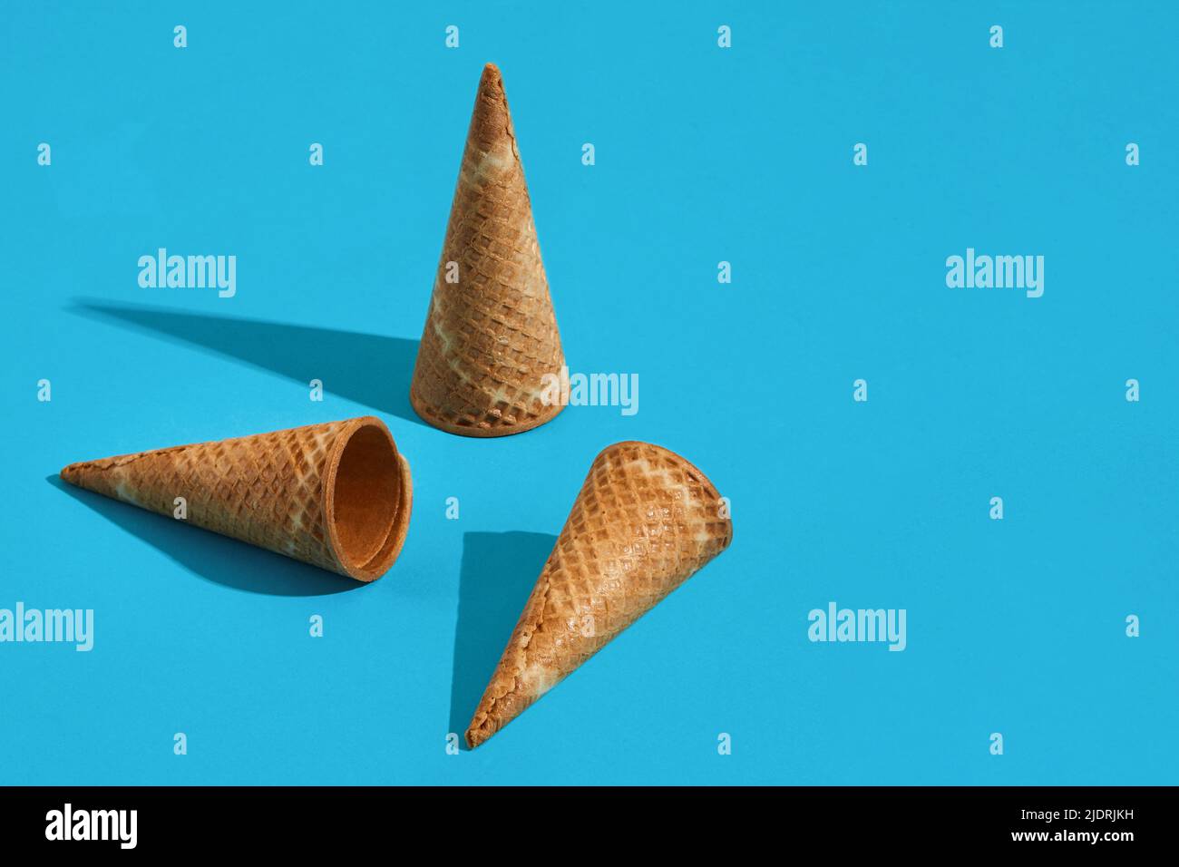 Three waffle ice cream cones with shadow on a blue background Stock ...