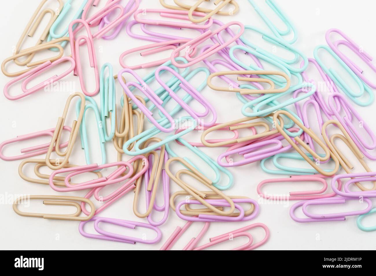 Multicolored paper clips scattered as textured background in full ...