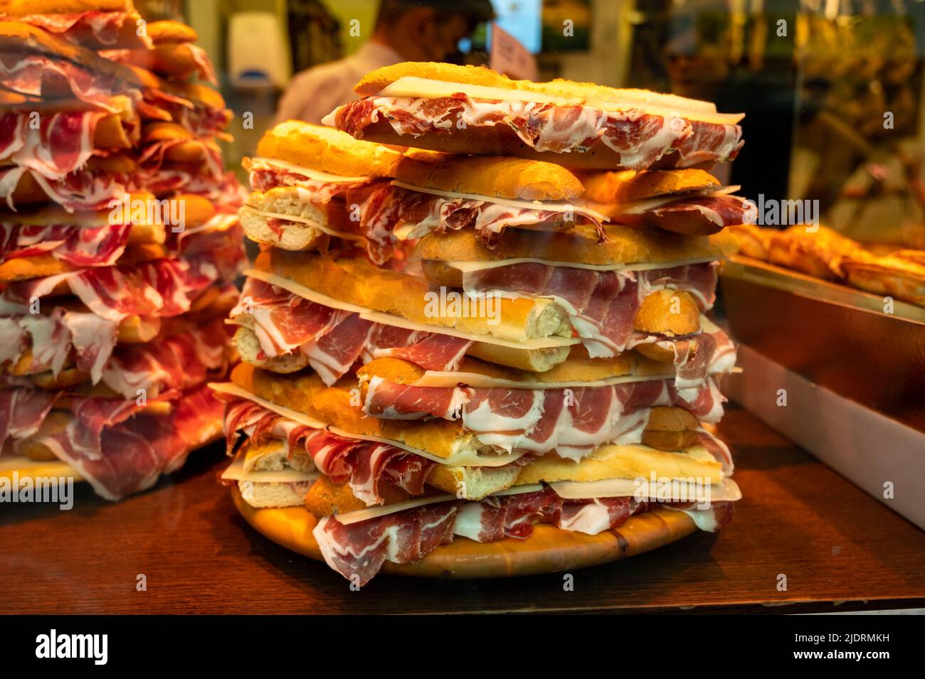 Spanish street food, fresh baked baguette bread with sliced iberian ...