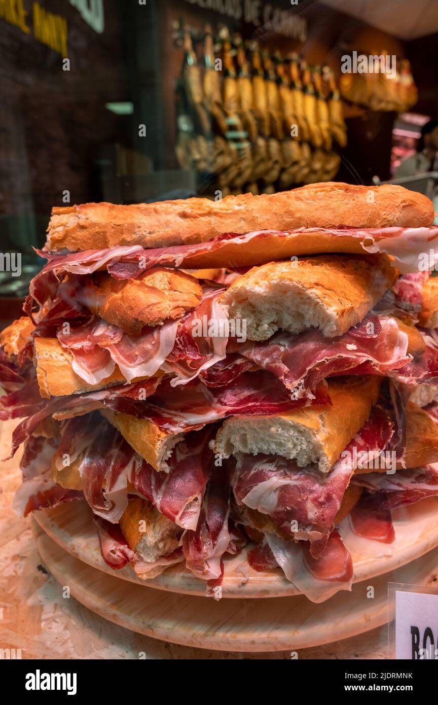 Spanish street food, fresh baked baguette bread with sliced iberian ...