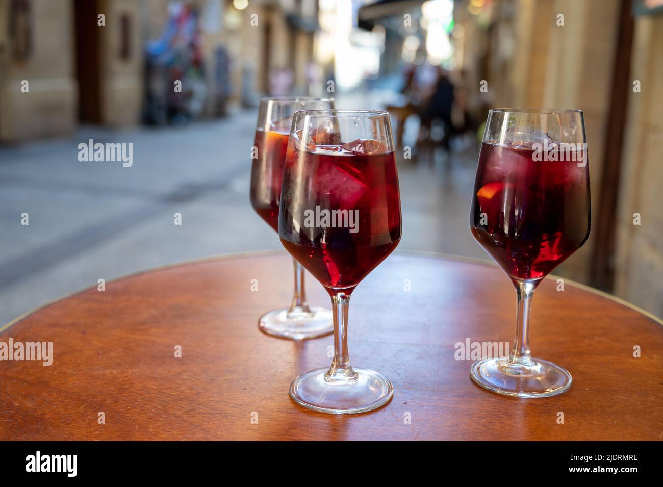 Glasses of cold sangria wine served outdoor in bar with view on old ...