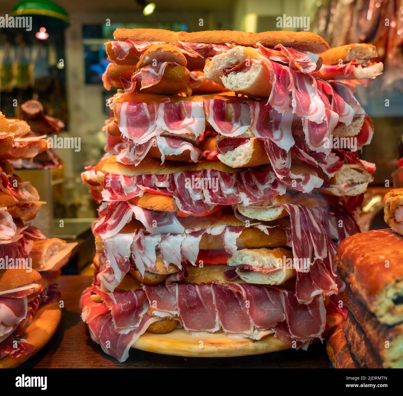 Spanish street food, fresh baked baguette bread with sliced iberian ...