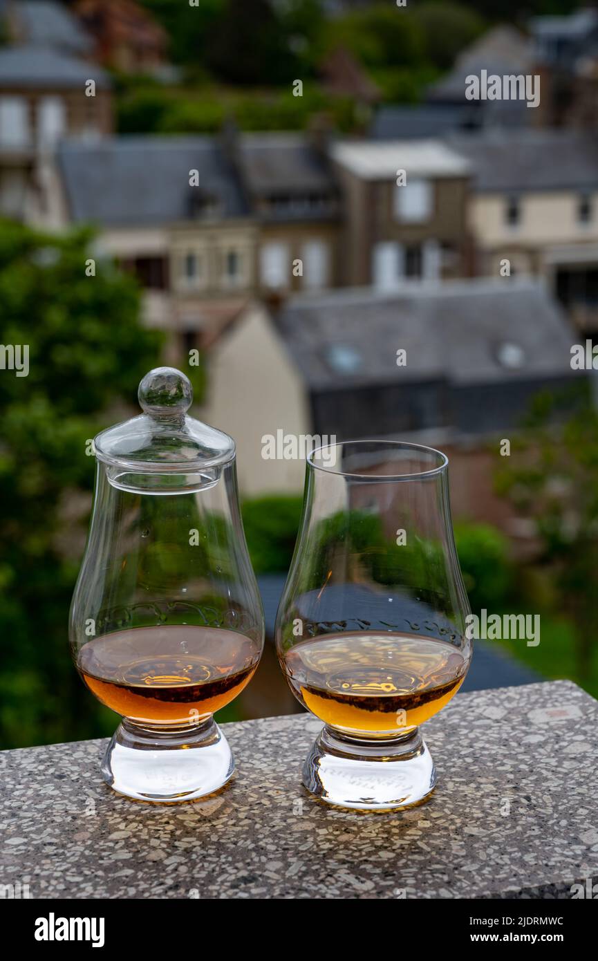Two drams of scotch whiskey with view on old houses on background ...