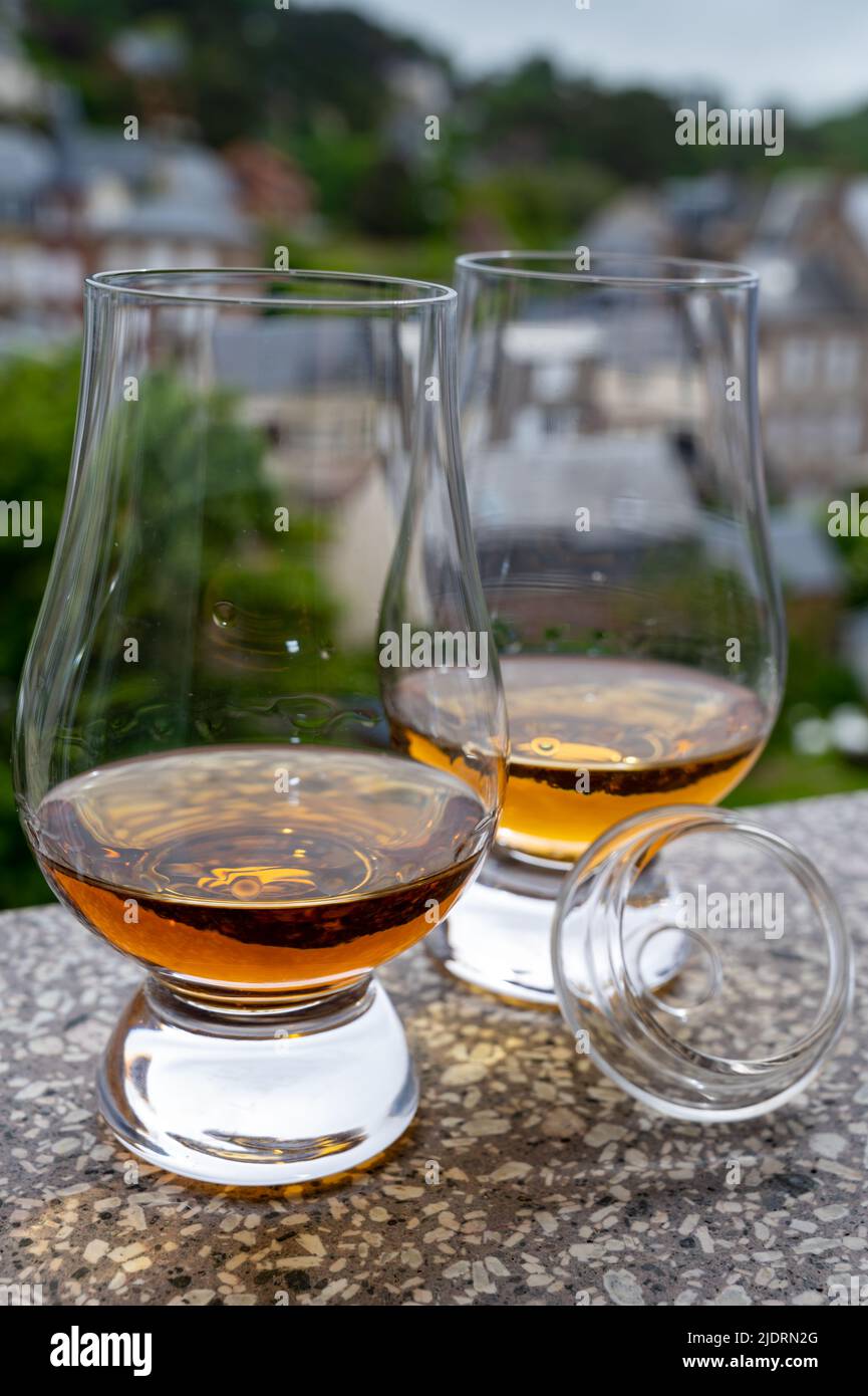 Two drams of scotch whiskey with view on old houses on background ...