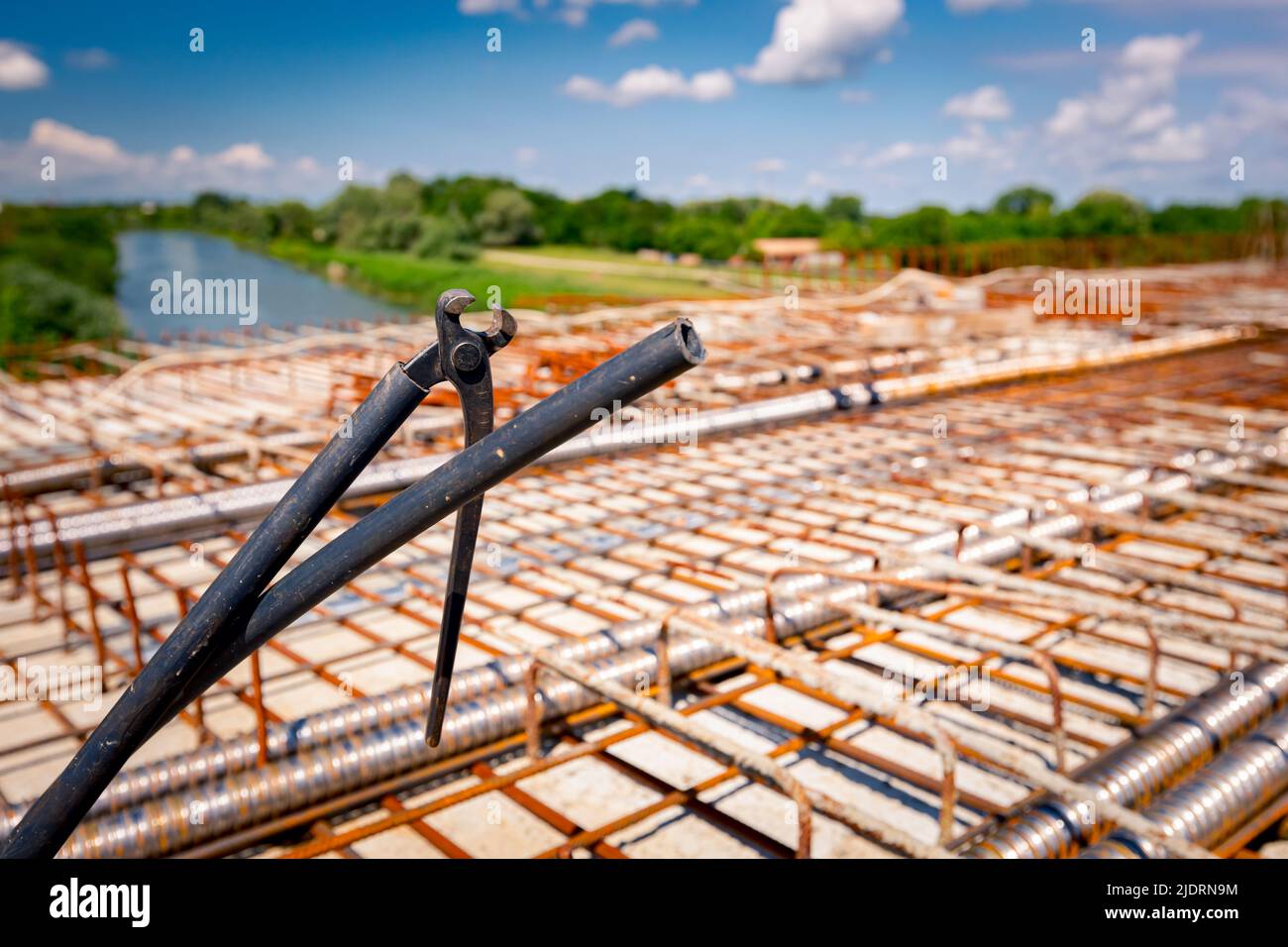 Metal pliers for binding wire reinforcement hung on a plastic tube ...