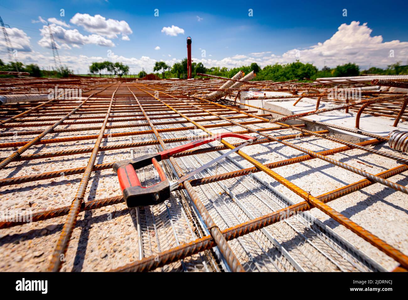A hand hacksaw for metal set on rusty square reinforcing mesh that was ...
