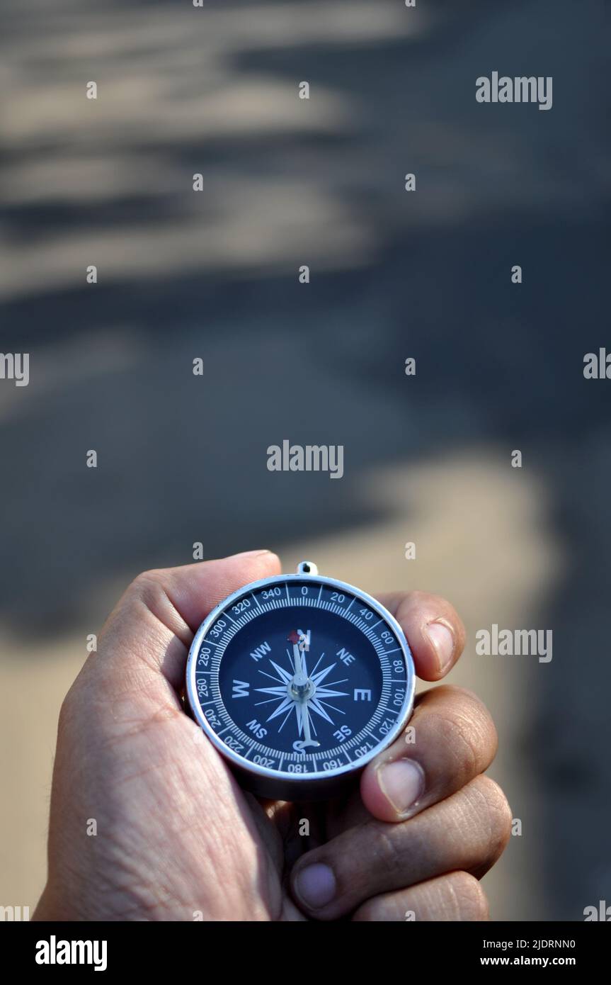 Hand holding the navigation compass blur background vertical Stock ...