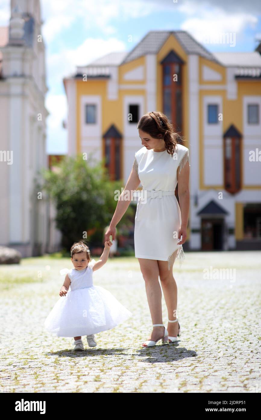 Two beauties in white. Mom and little daughter in a white dress ...