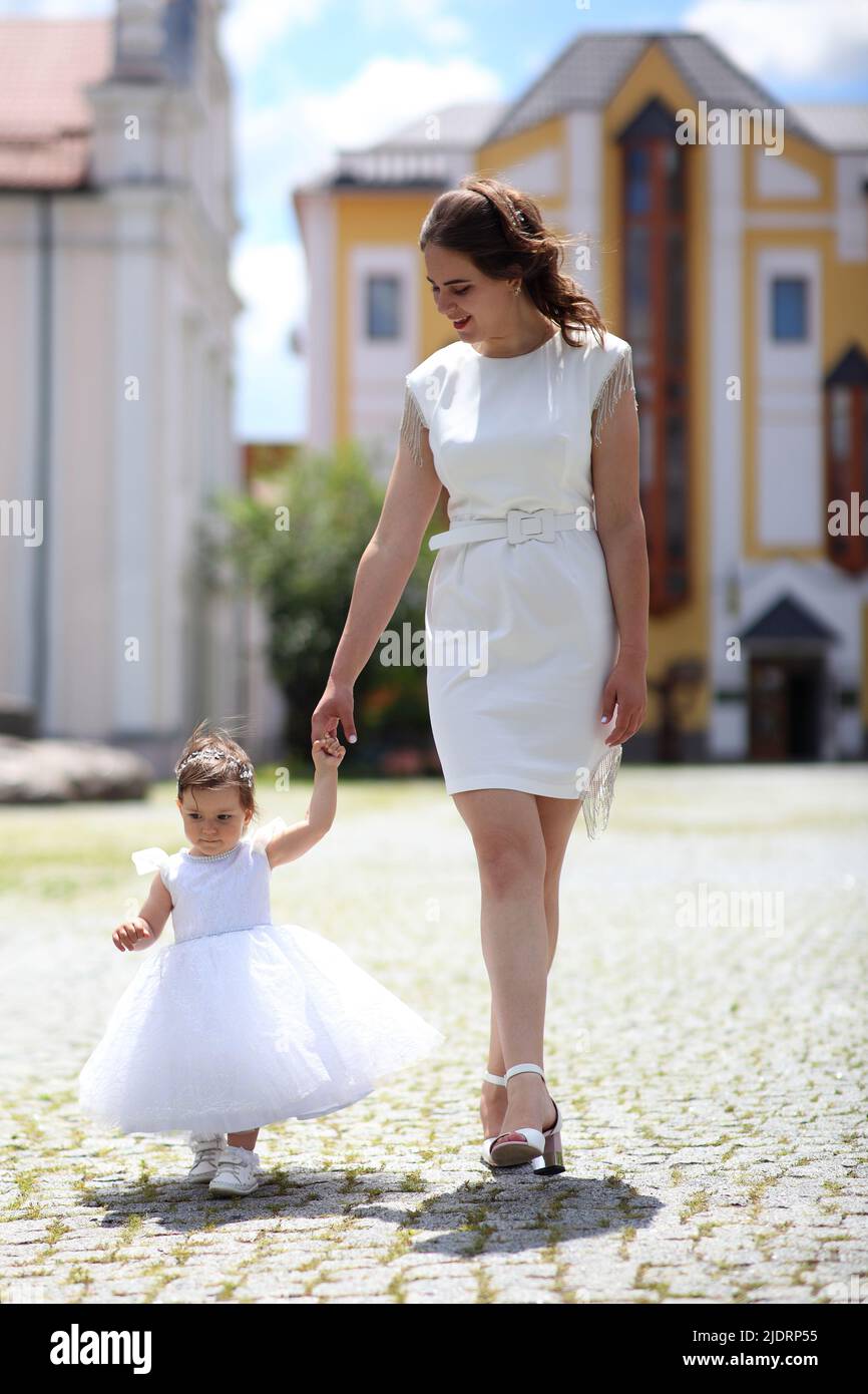 Two beauties in white. Mom and little daughter in a white dress ...