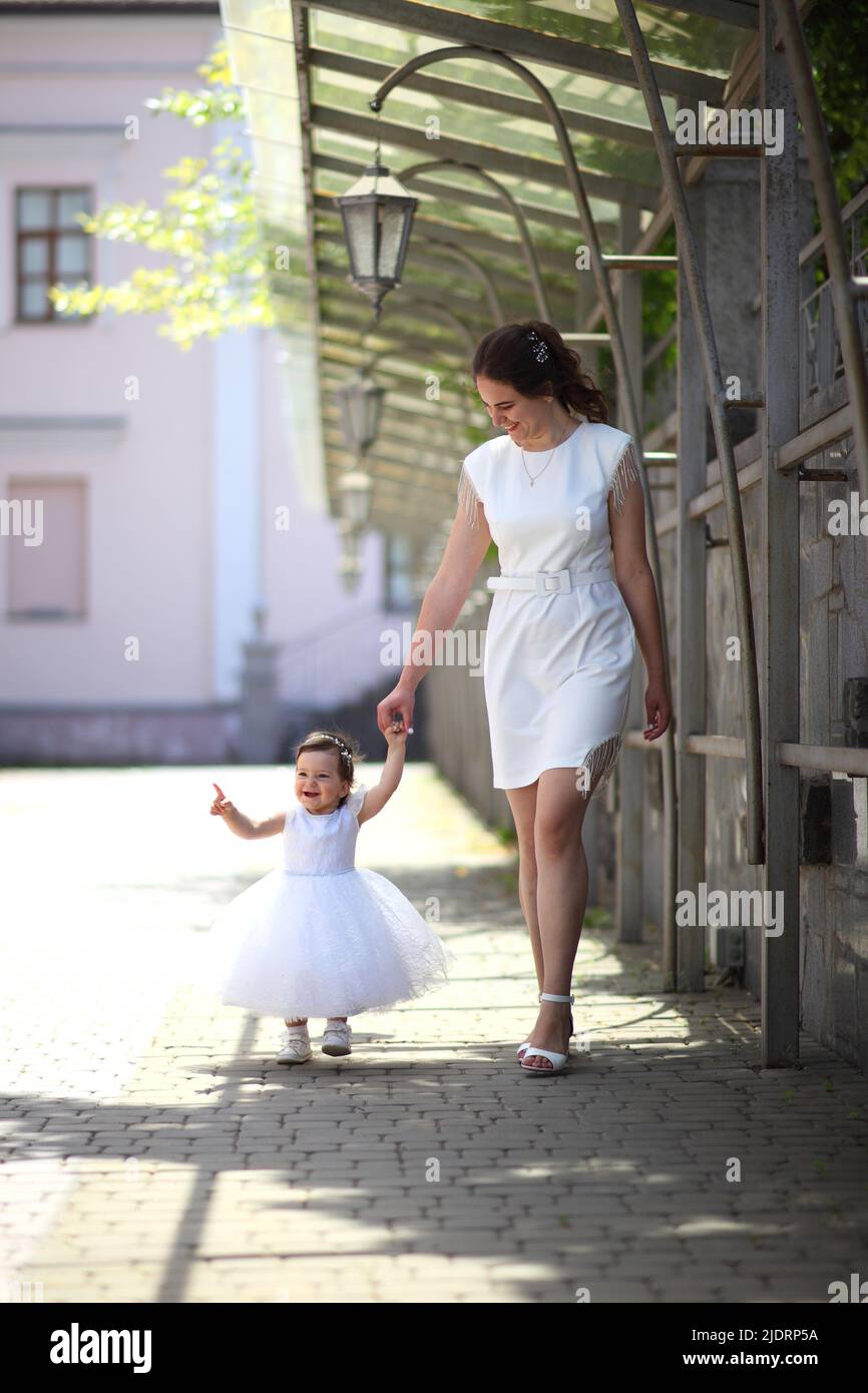 Two beauties in white. Mom and little daughter in a white dress ...