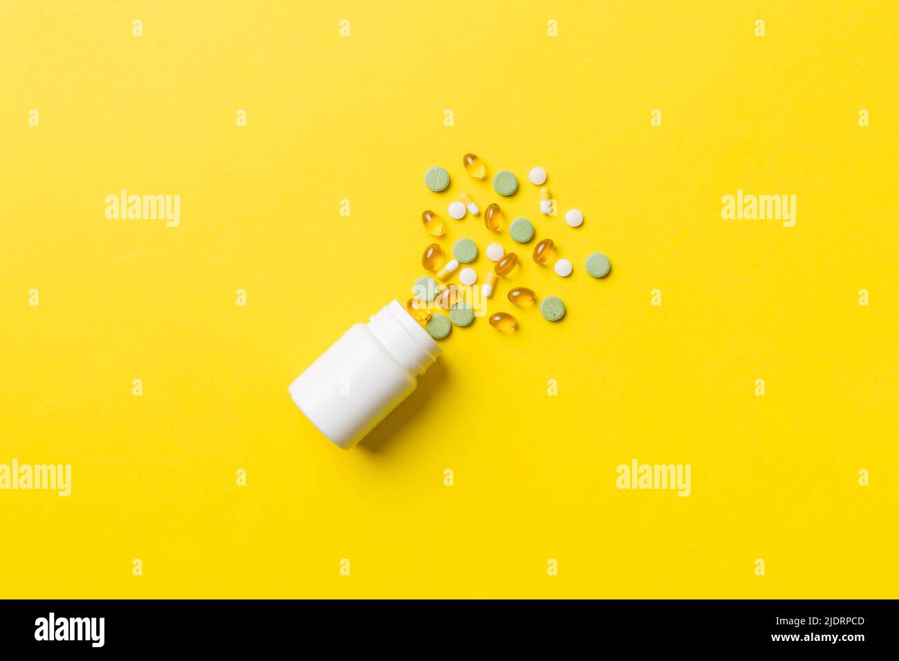 Multicolored pills and capsules in plastic bottle on Colored background ...