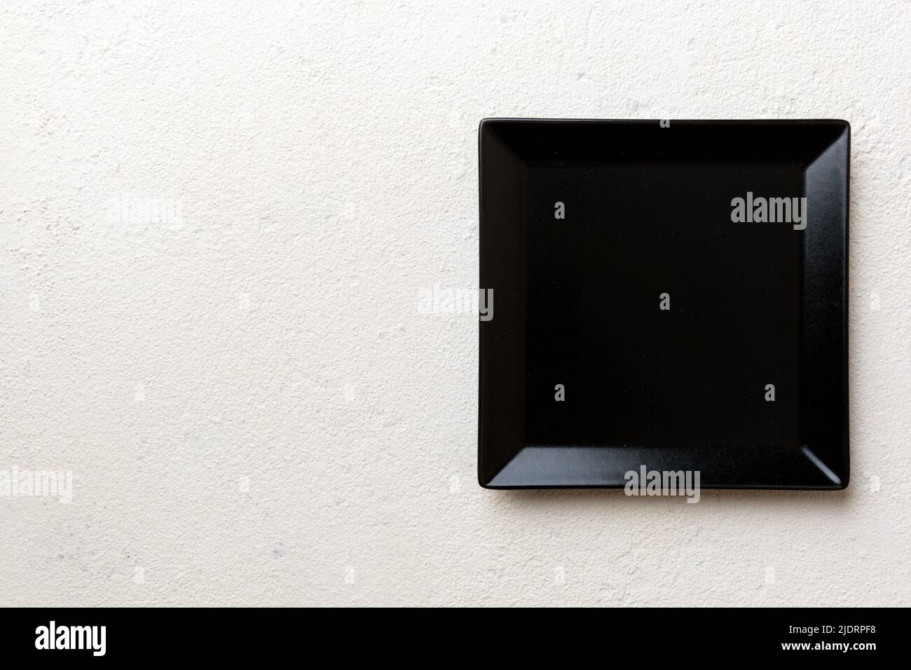 Top view of empty square plate on cement background. Empty space for ...