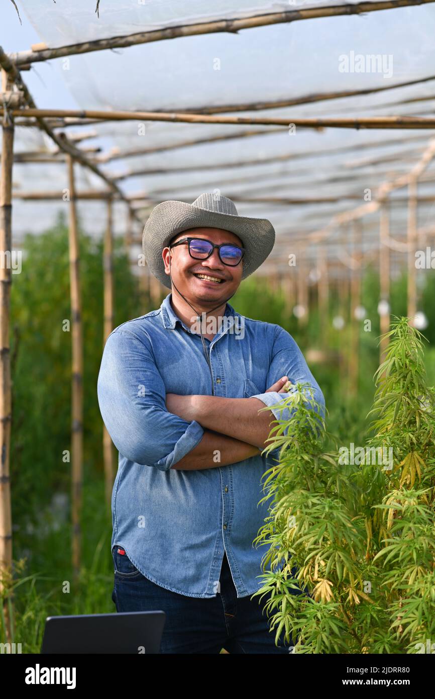 Portrait of young male innovative farmer standing among his commercial ...