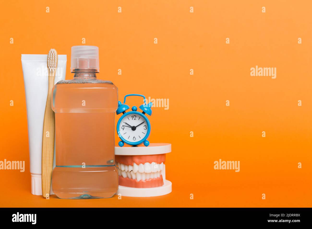 Mouthwash and other oral hygiene products on colored table top view ...