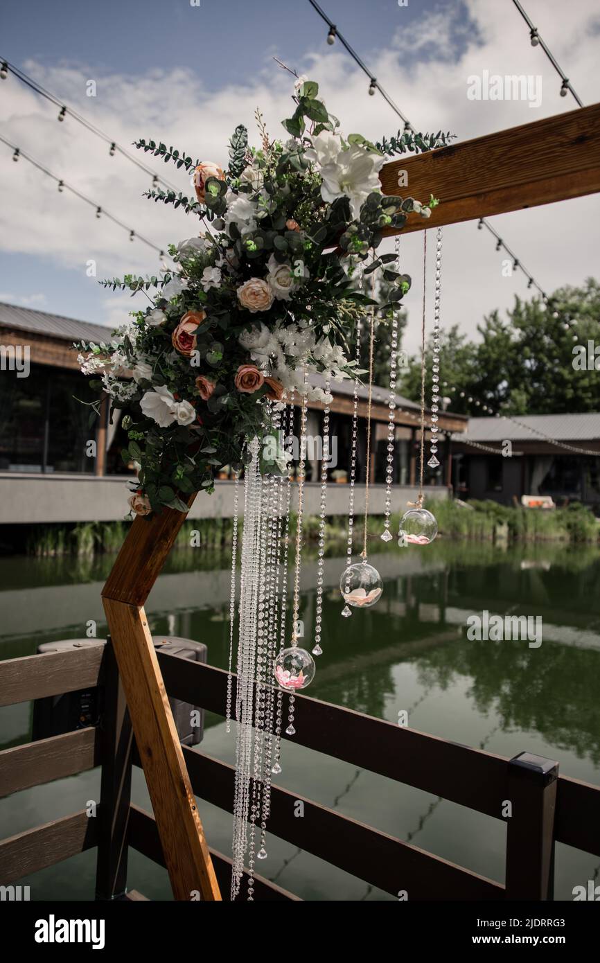 a wedding arch decor with crystals and flowers in the park near the ...