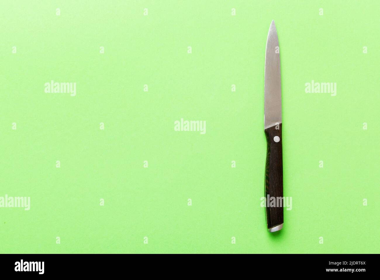 A simple kitchen knife with wooden handle, top view isolated on green ...