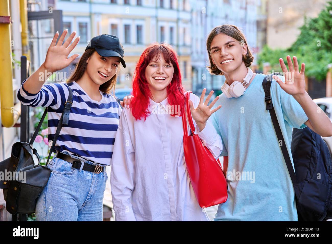Group of teenage friends looking at camera waving hand, outdoor Stock ...