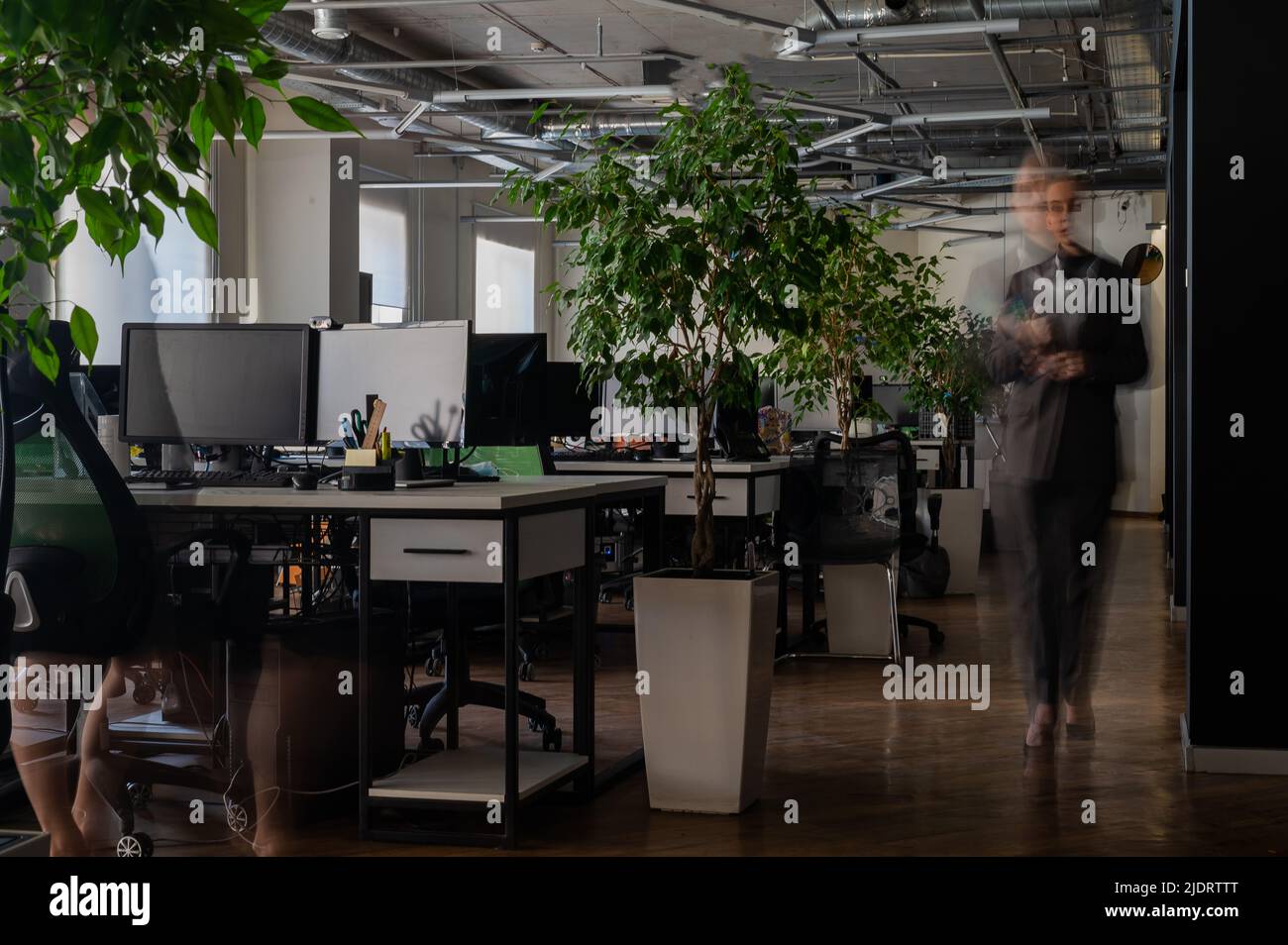 Blurred female figure in motion in the office Stock Photo - Alamy