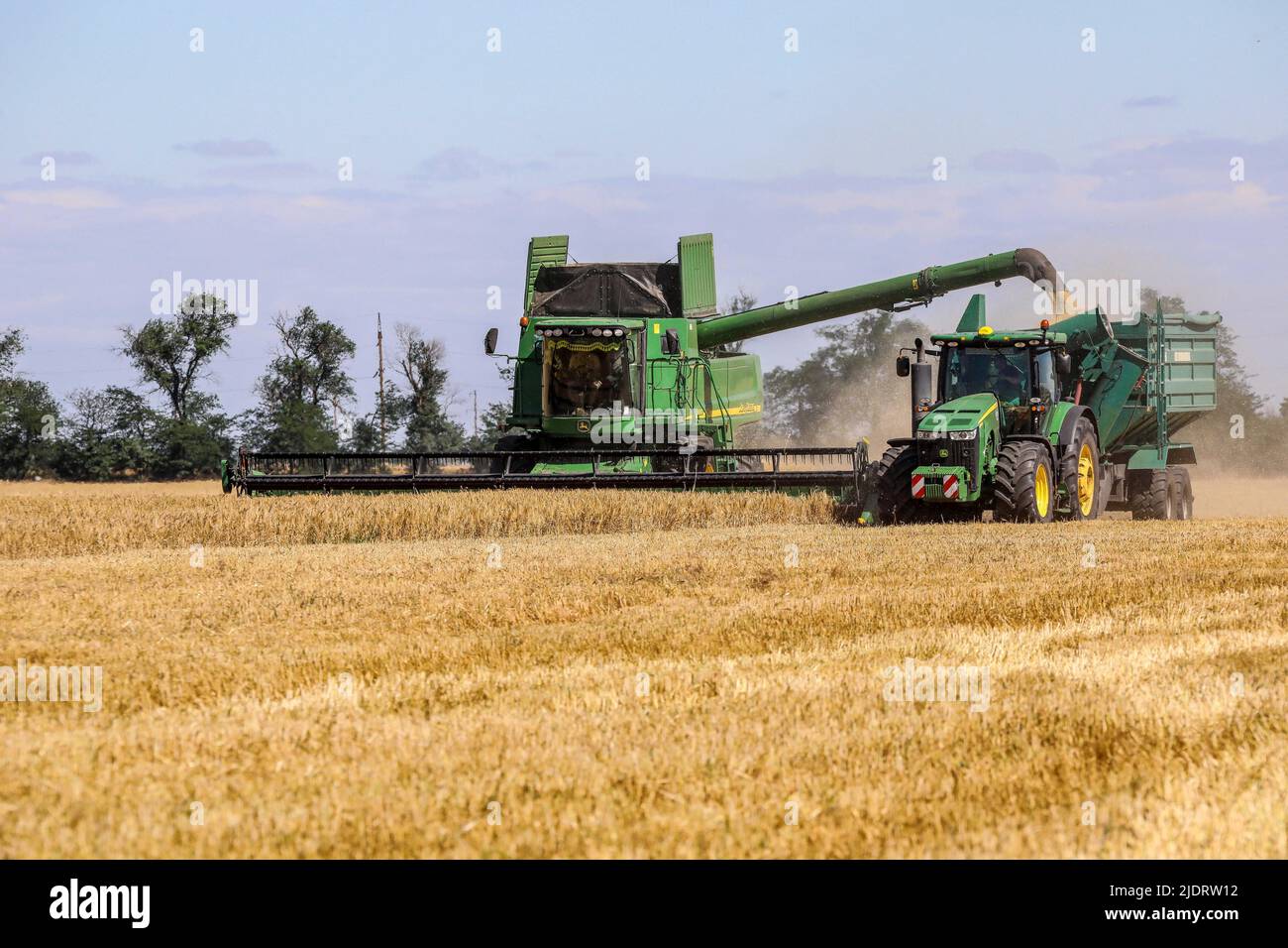 A combine harvester collects grain crops in a field in Odesa Region ...