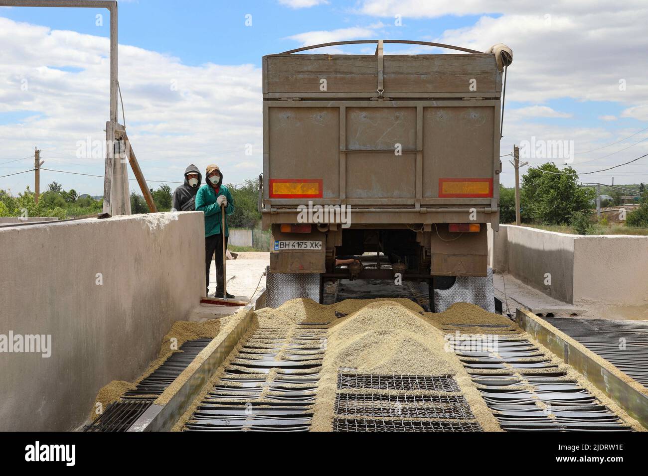 Workers stand by a grain truck at a facility in Odesa Region, southern ...