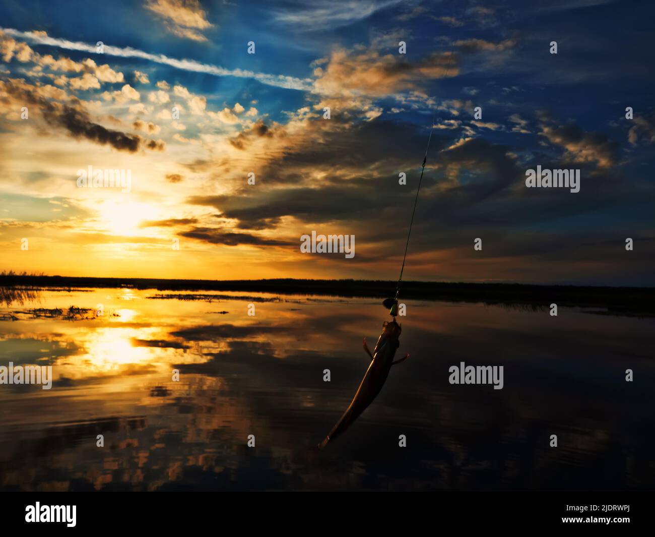 Fishing at sunset. Catching predatory fish on spinning. Sunset colors ...