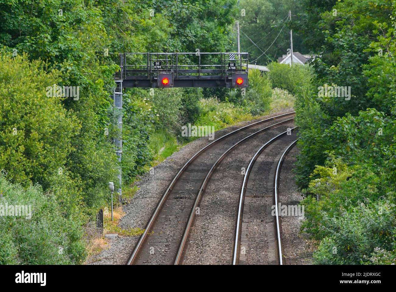 Axminster, Devon, UK. 23rd June 2022. Red signal lights above the rail ...