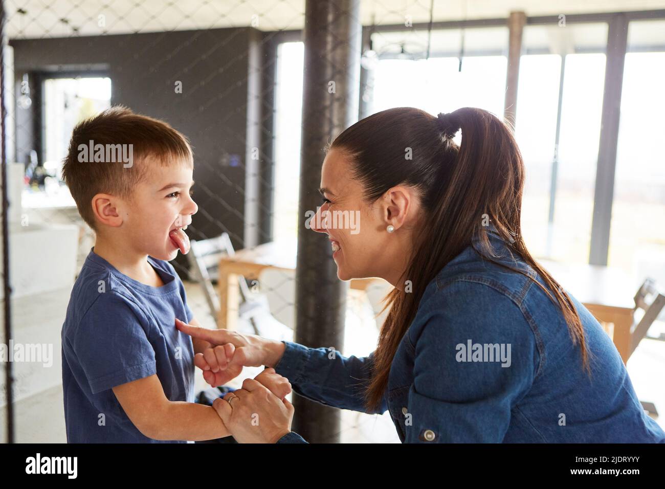 Boy shows his mother playing and making mischief the tongue as a rascal ...