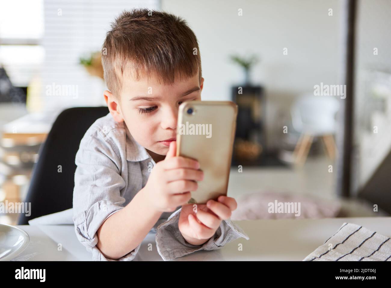 Little boy reads a text message on the smartphone or on social media ...