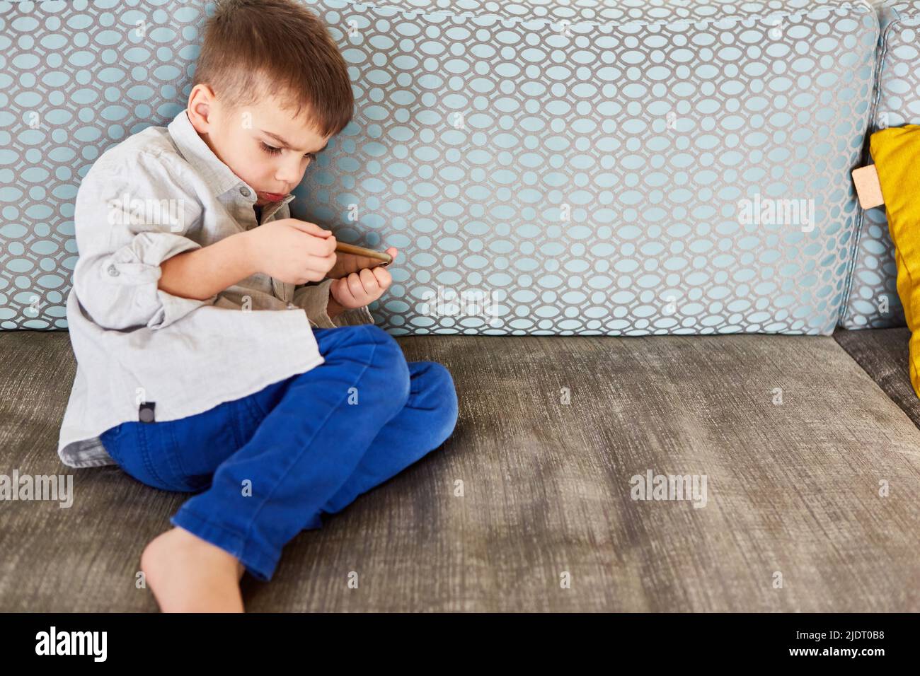 Little boy reads a text message on his smartphone or on social media ...