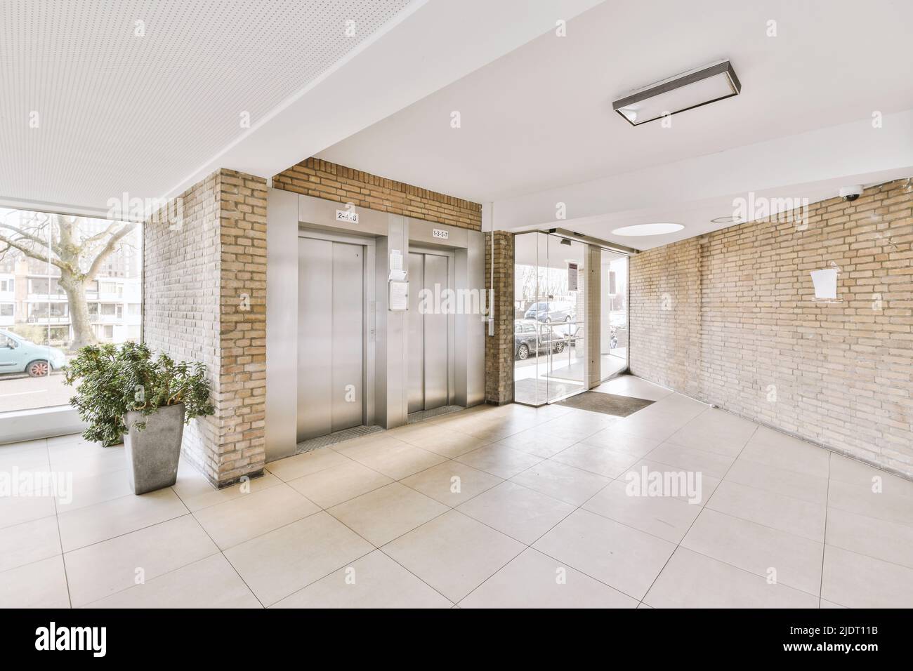 Shiny elevator with closed door located in illuminated hall of ...