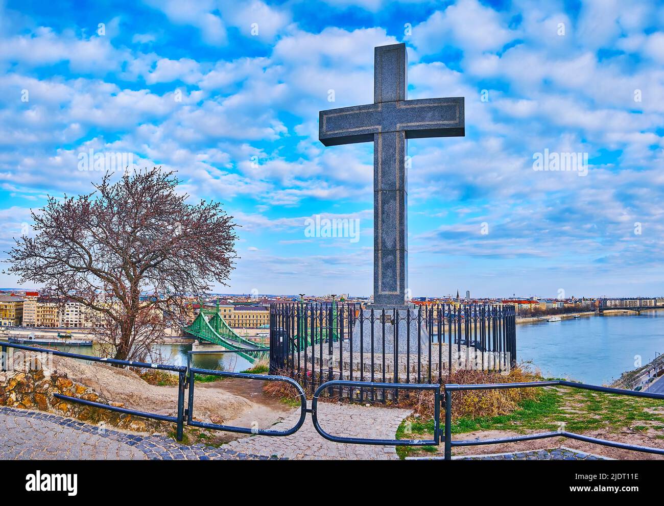 The stone Cross of Cave Church on the Gellert Hill against the Liberty ...