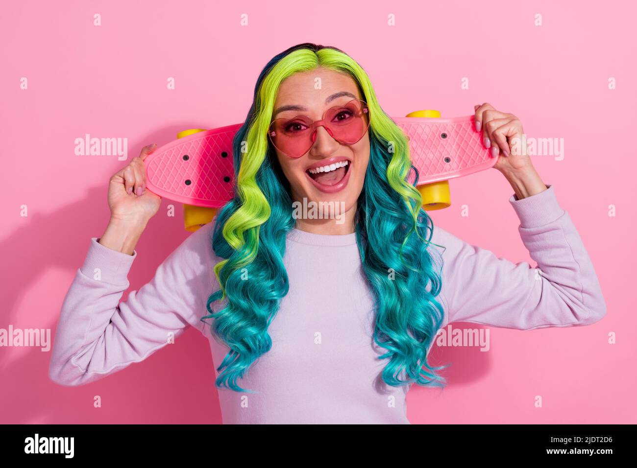 Photo of overjoyed positive person have good mood hold skateboard ...