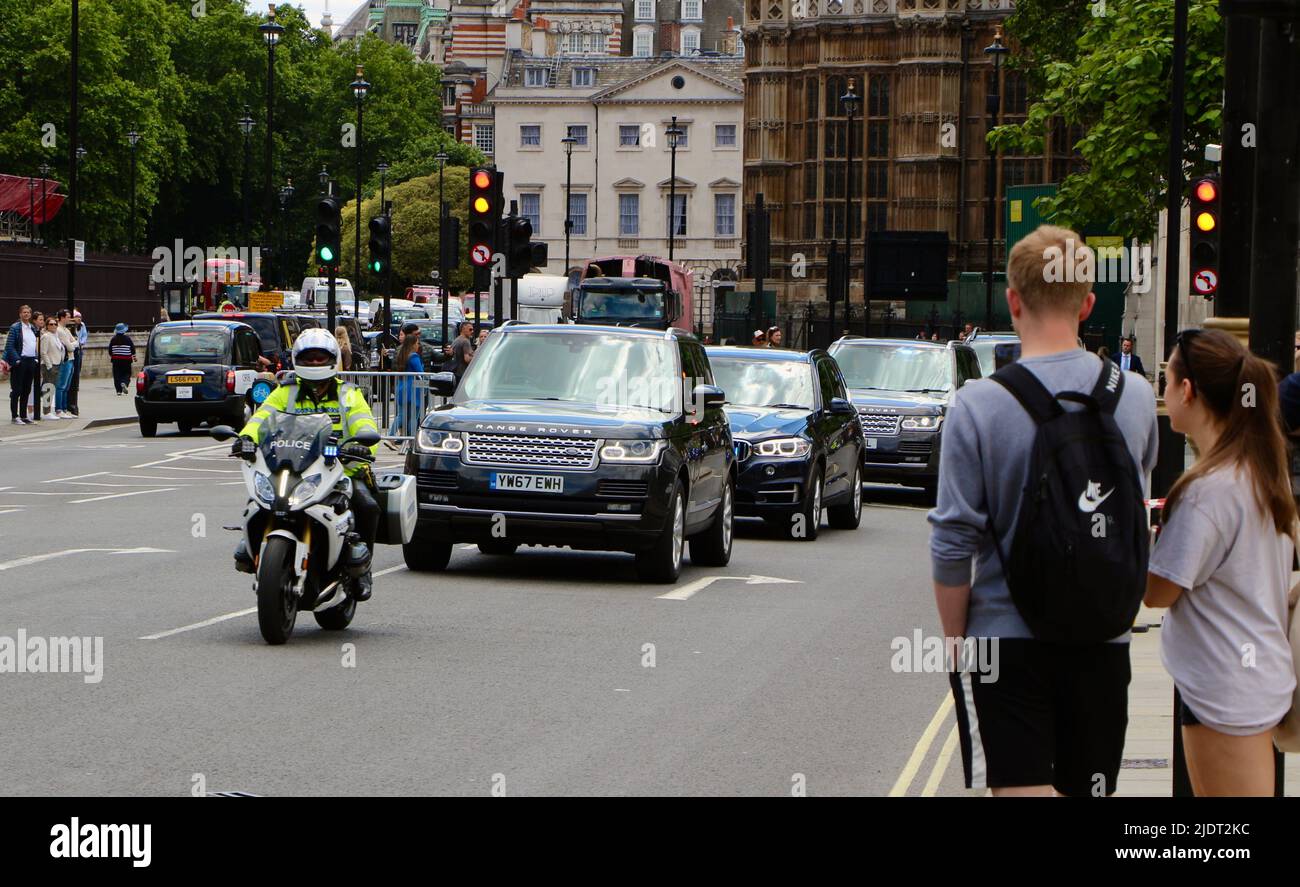 A convoy of ministerial cars and security with a police escort ...