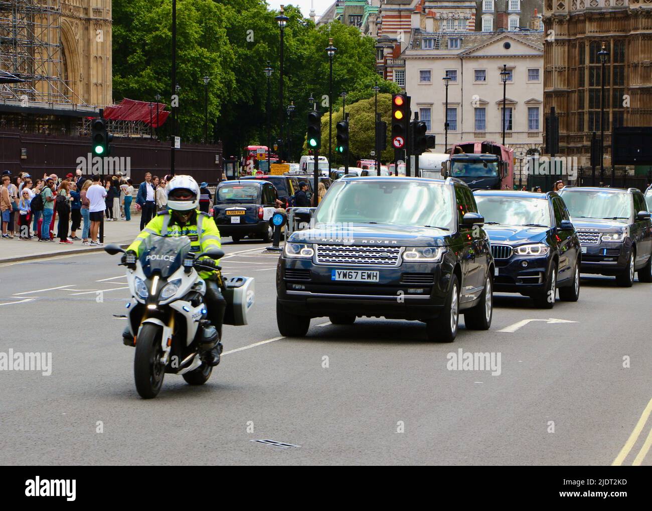 A convoy of ministerial cars and security with a police escort ...