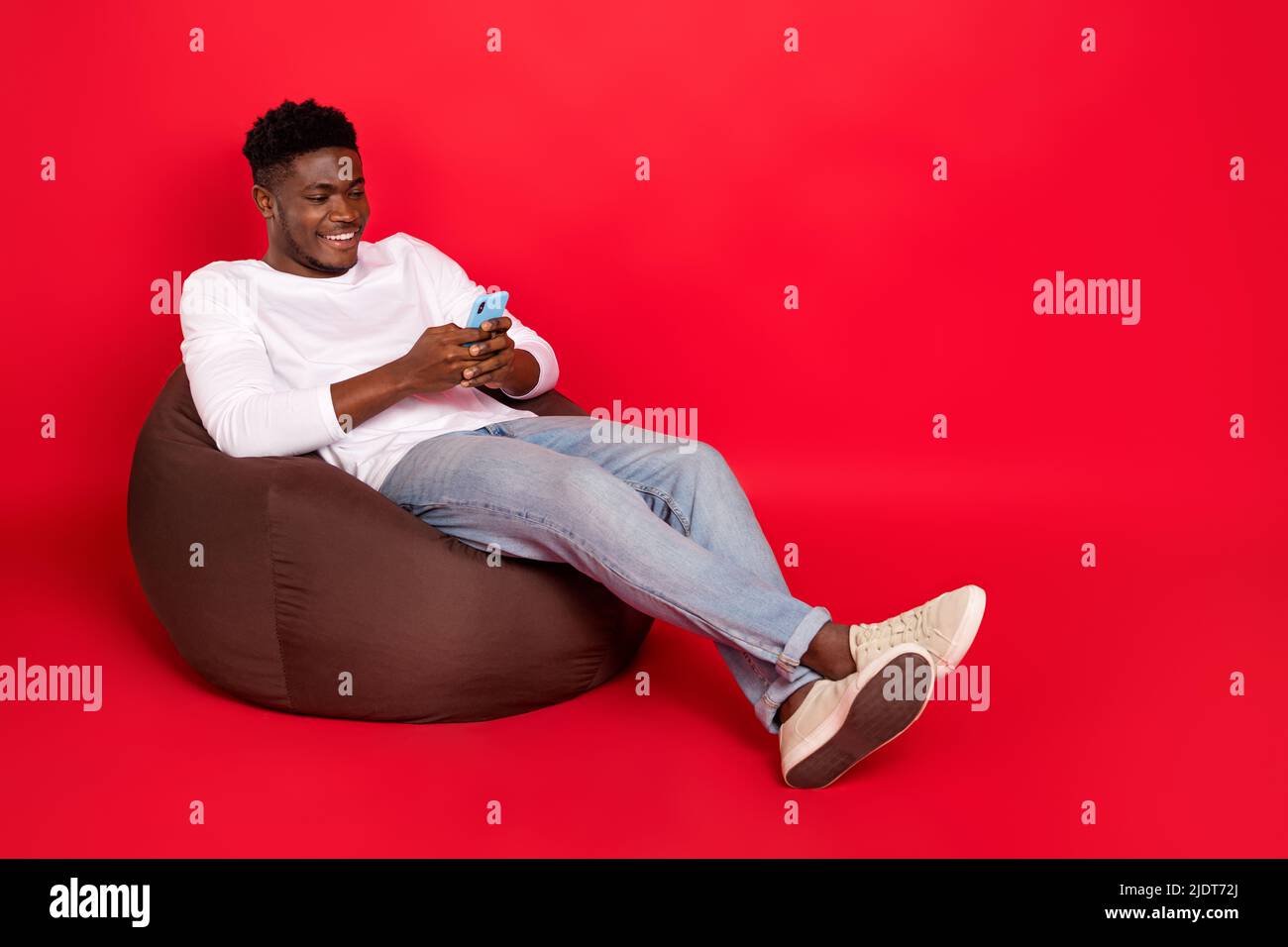 Full body photo of guy blogger sit bean chair use device like post ...