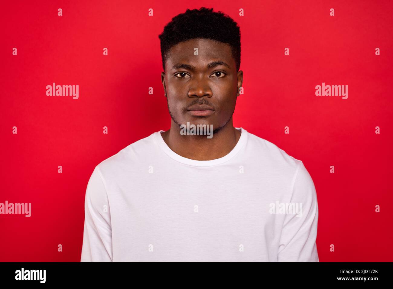 Portrait of calm young person look camera isolated on vibrant red color ...