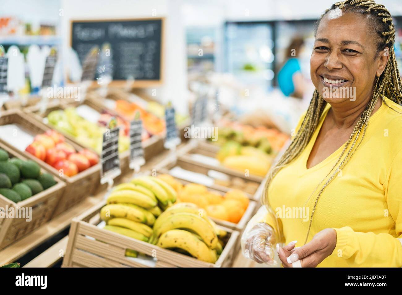African female customer buying organic food fruits inside eco fresh ...