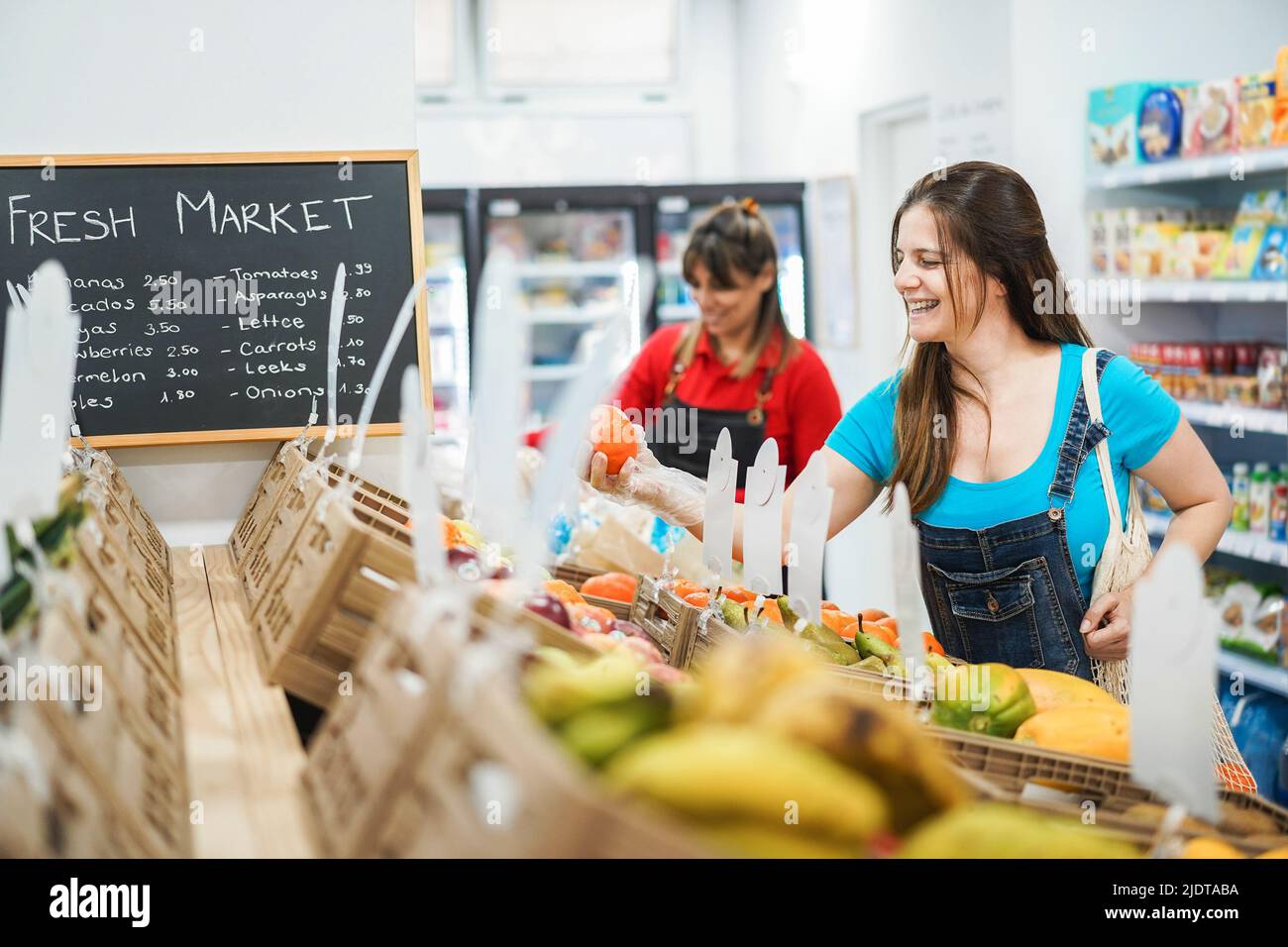 Female customer buying organic food fruits inside eco fresh market ...