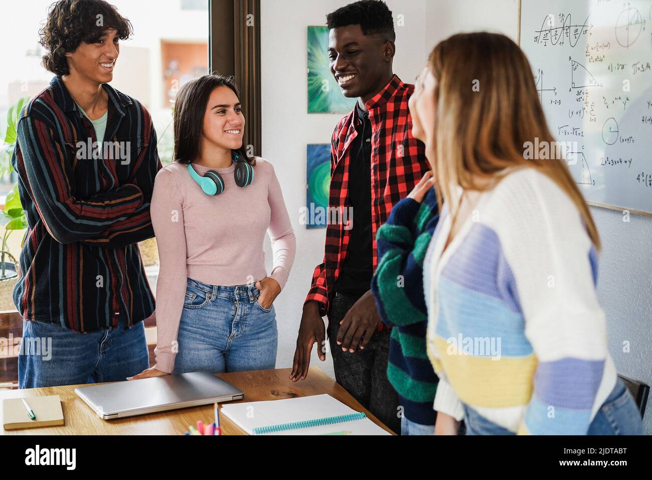Young multiracial friends talking inside classroom at school - Soft ...