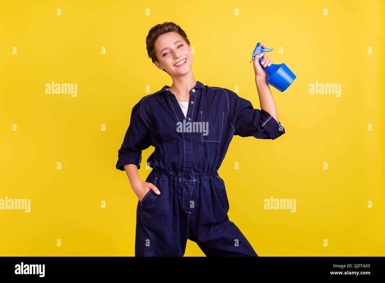 Portrait of attractive cheerful brown-haired girl using pulverizer ...