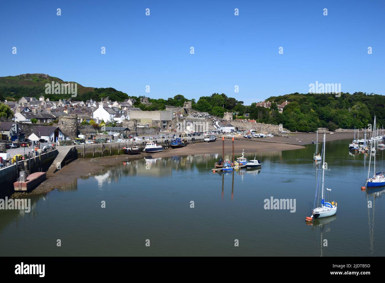 Blue sky and sunshine on the Conwy estuary with the harbour and boats ...