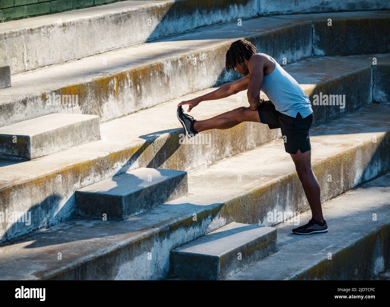 Athletic man stretching leg on steps Stock Photo - Alamy