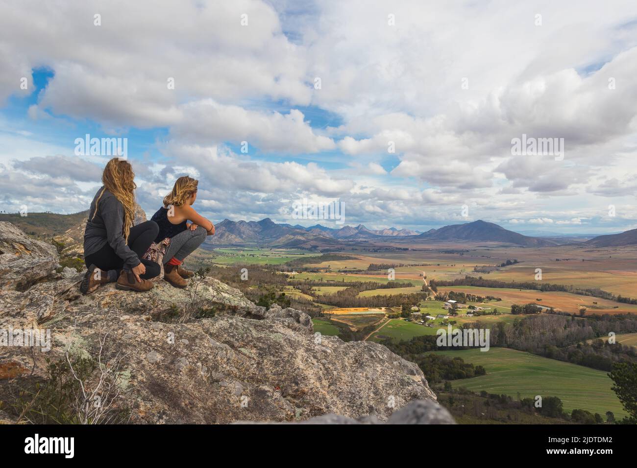 Two girls on a mountain looking out over farmlands Stock Photo - Alamy