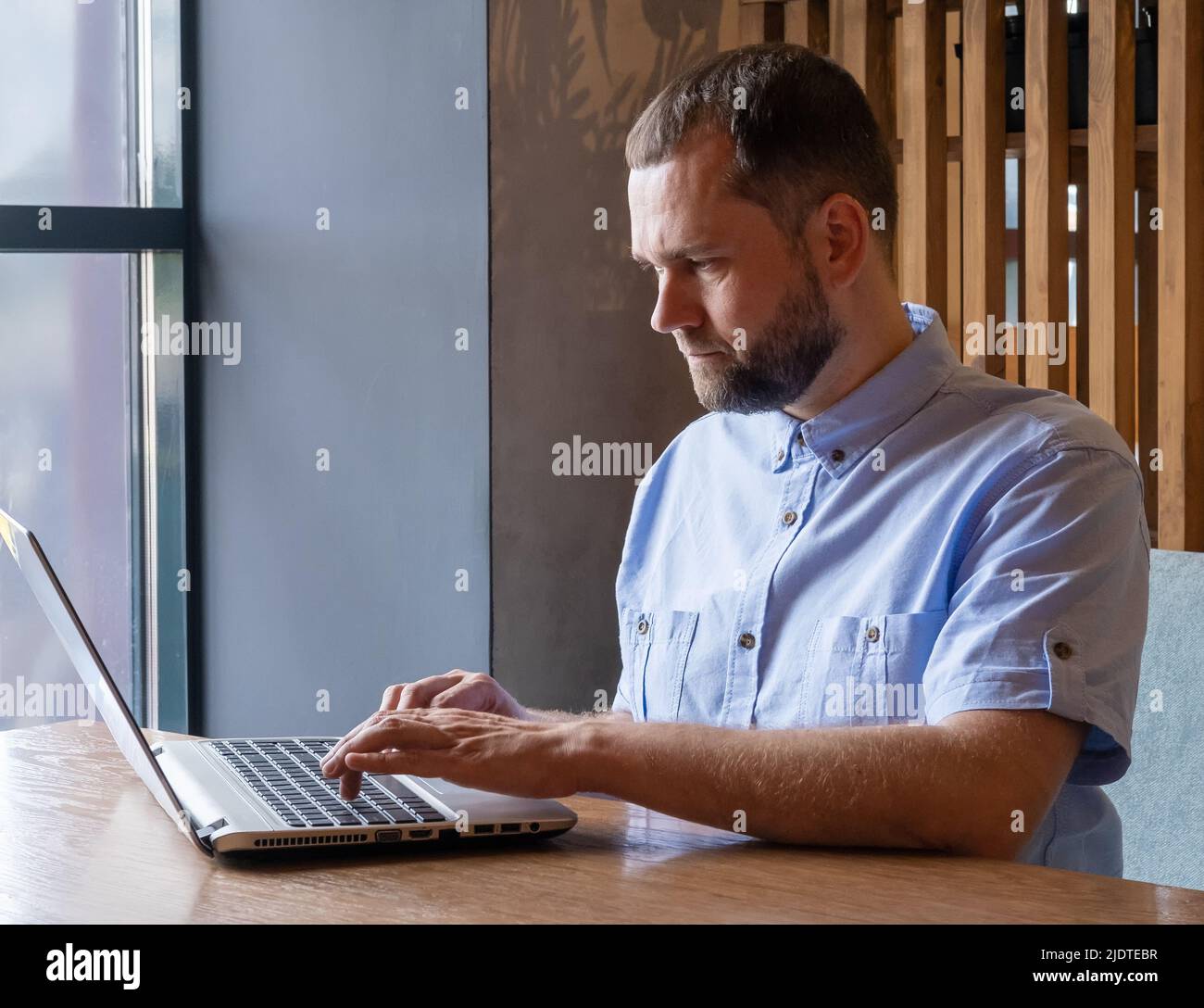 Serious handsome arabian man with beard is using laptop, reading email ...