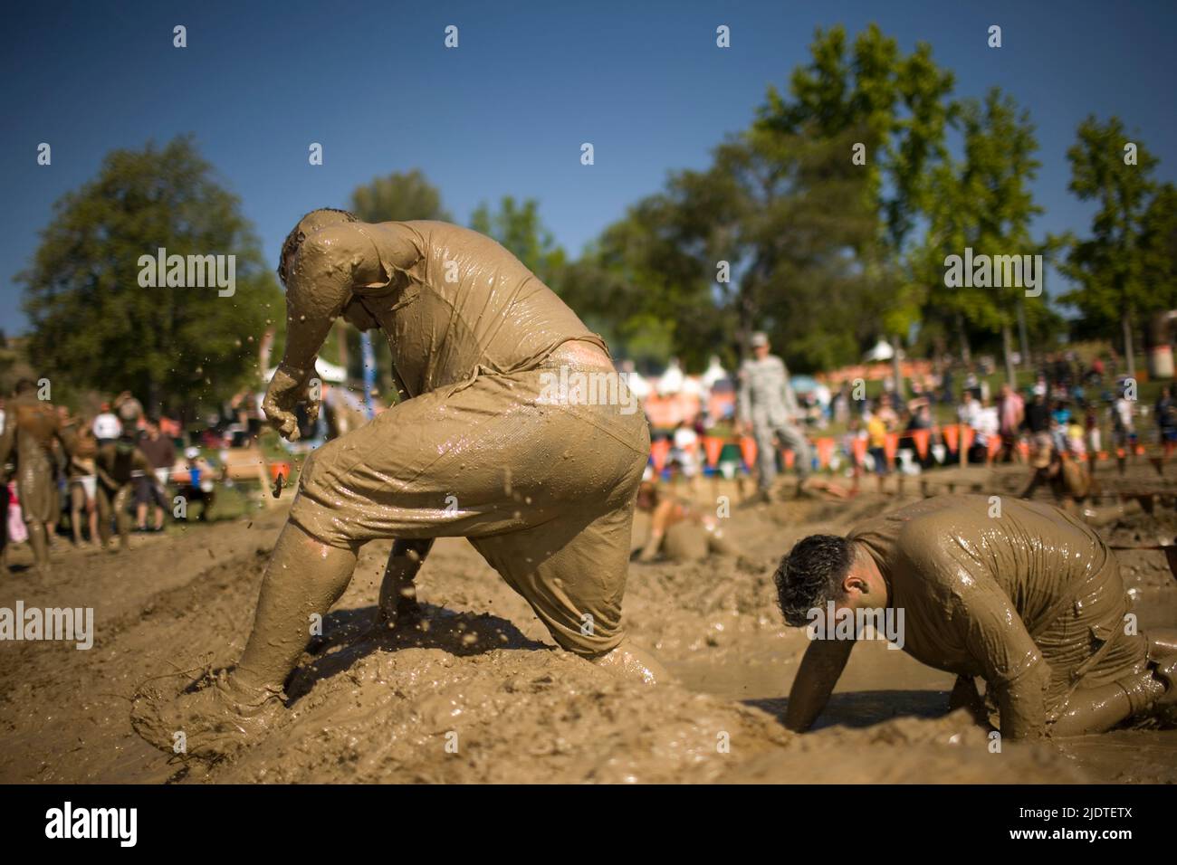 Sportsmen running in mud Stock Photo - Alamy
