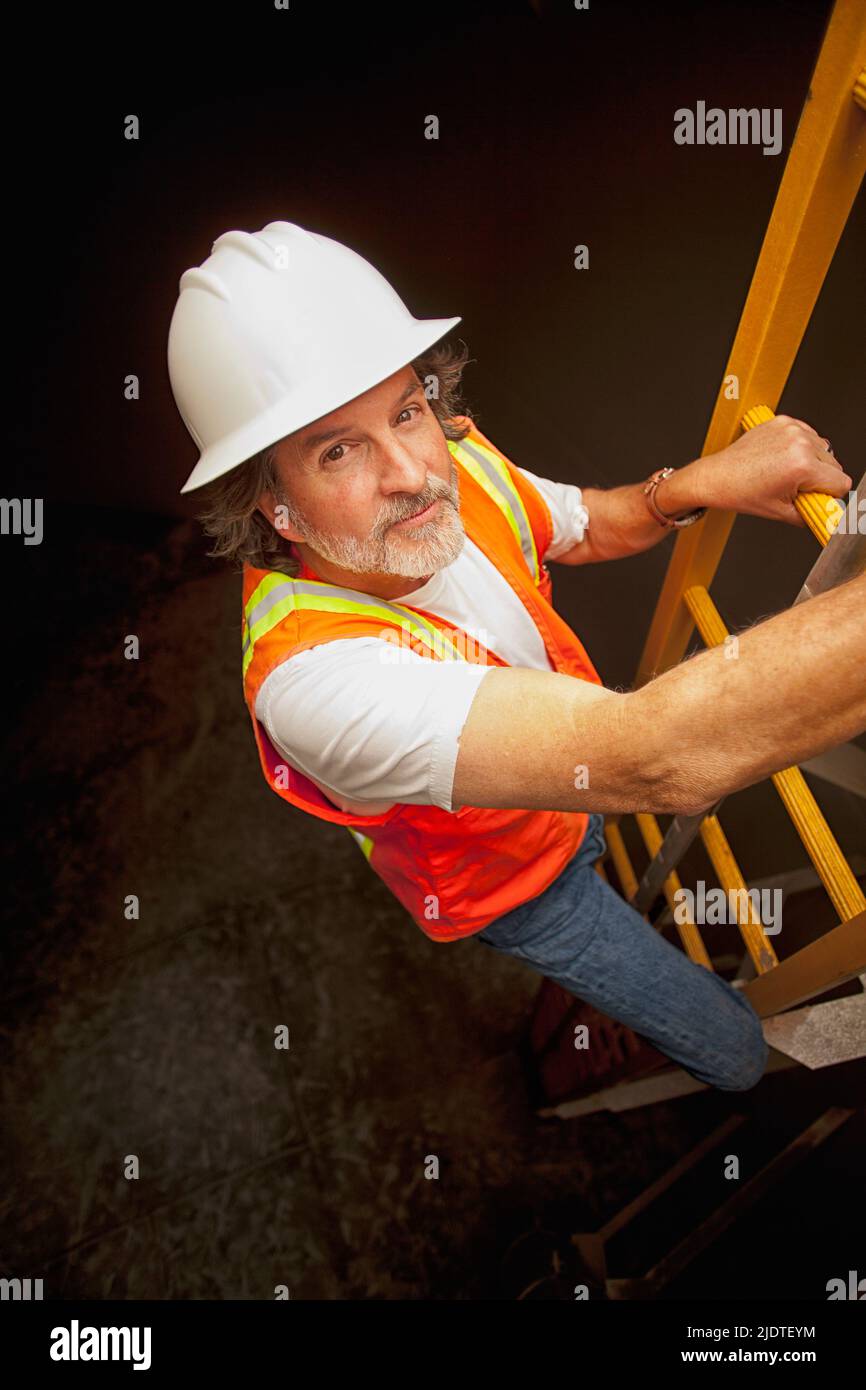 Worker descending ladder Stock Photo - Alamy