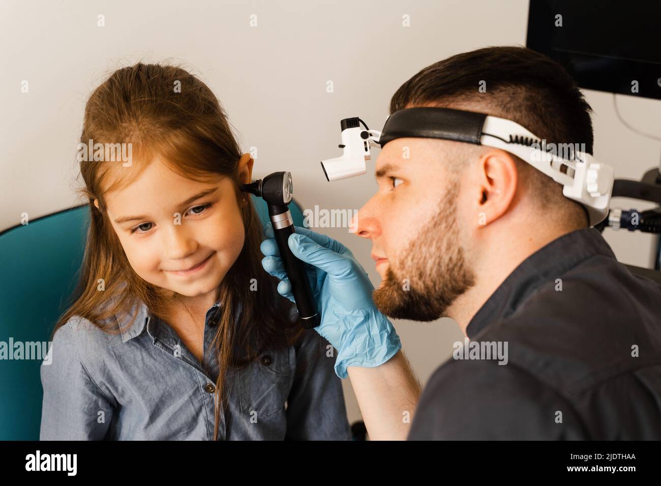 Otoscopy of child ears with otoscope. ENT doctor. Consultation with ...