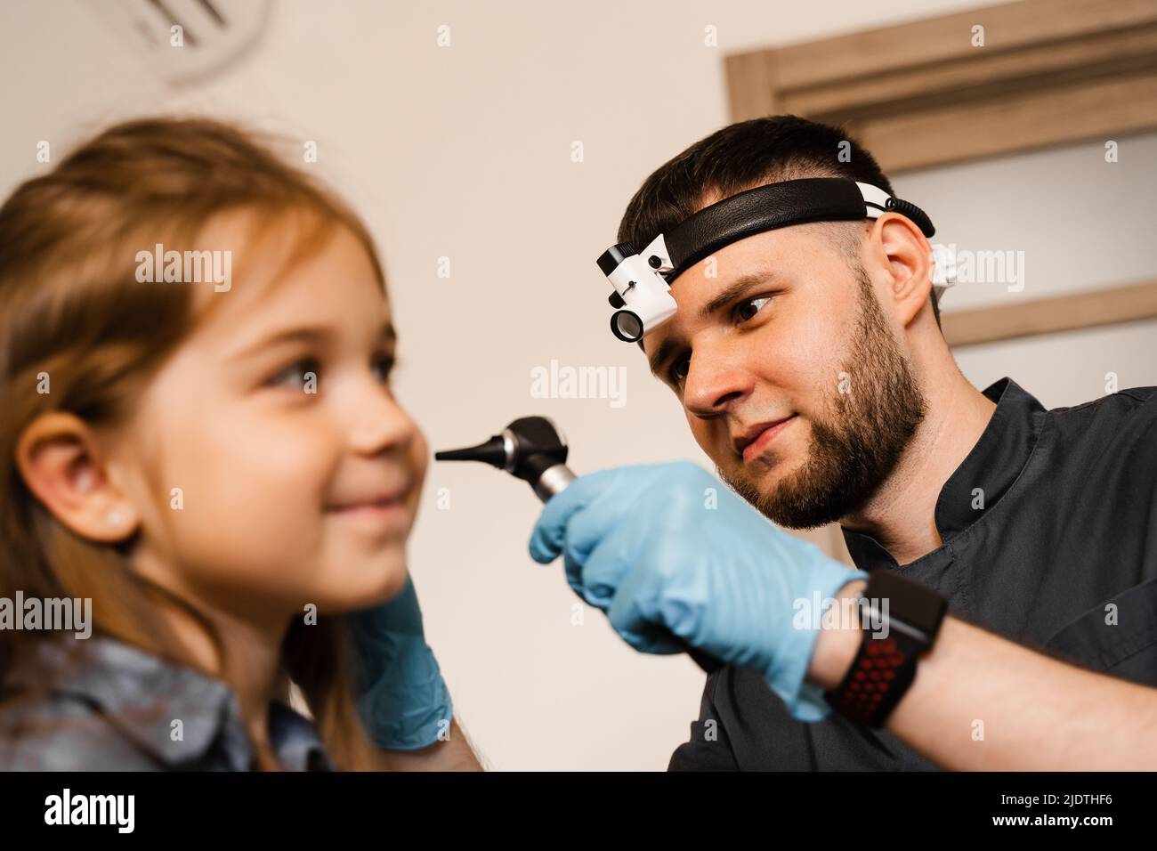 ENT doctor with otoscope. Otoscopy. Pediatrician otolaryngologist looks ...